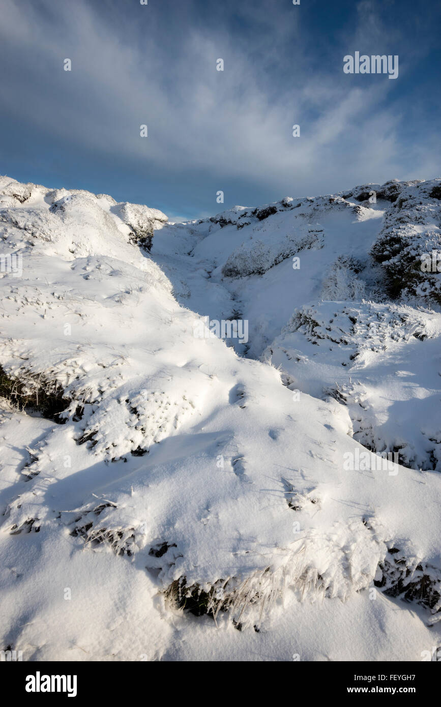 Snowy moorland ravine beside the Pennine way on Bleaklow in Derbyshire ...