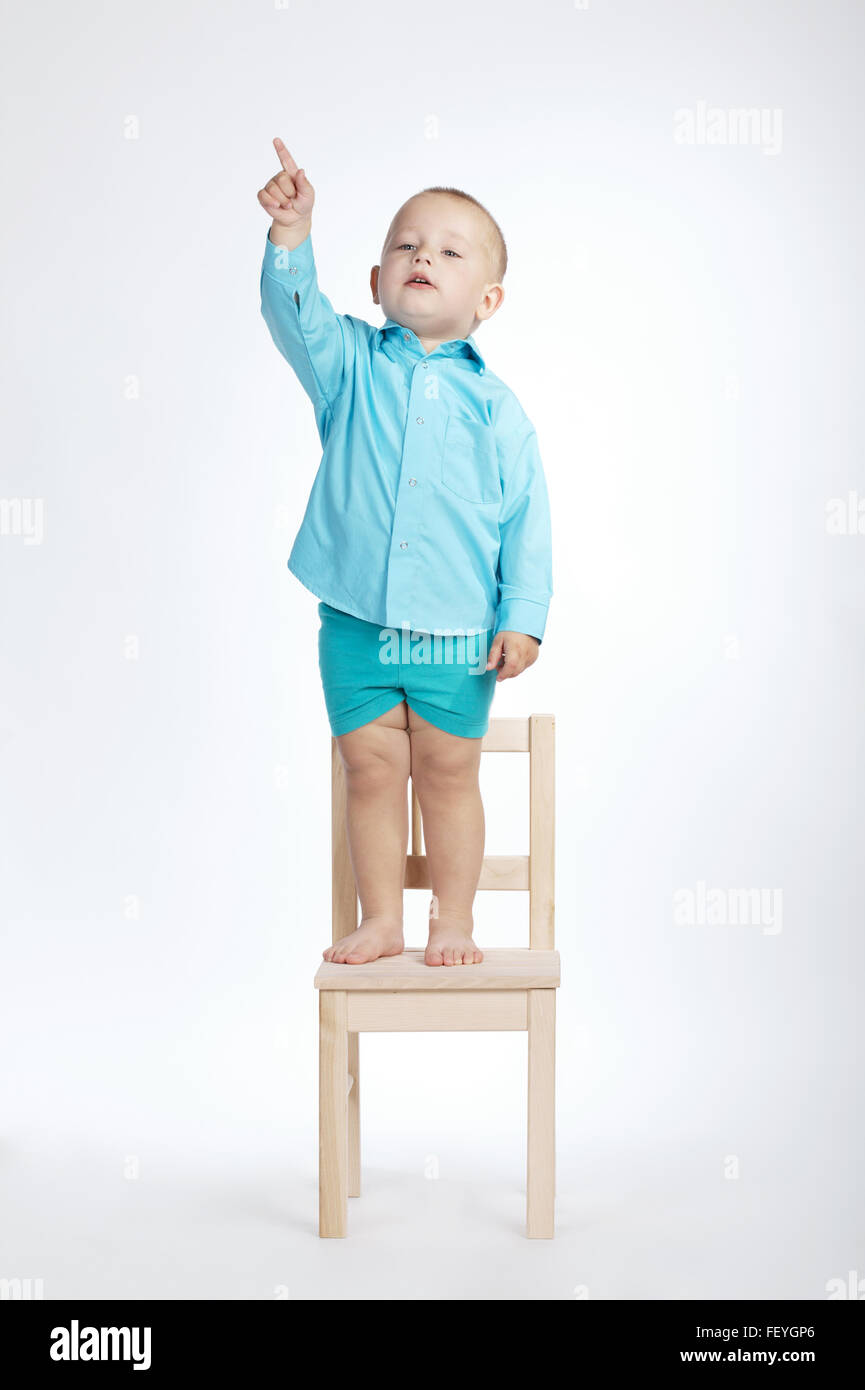 boy on chair and pointing his finger up Stock Photo - Alamy