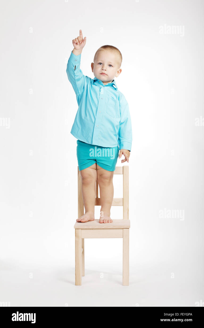boy on chair and pointing his finger up Stock Photo - Alamy