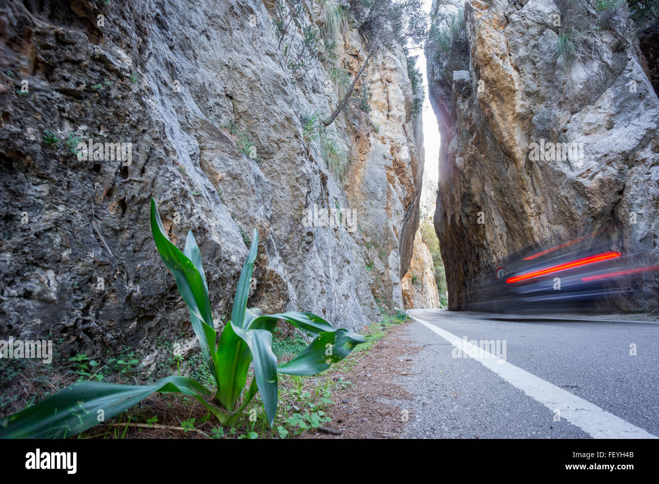 Asphalt road between rocks with car trail Stock Photo - Alamy