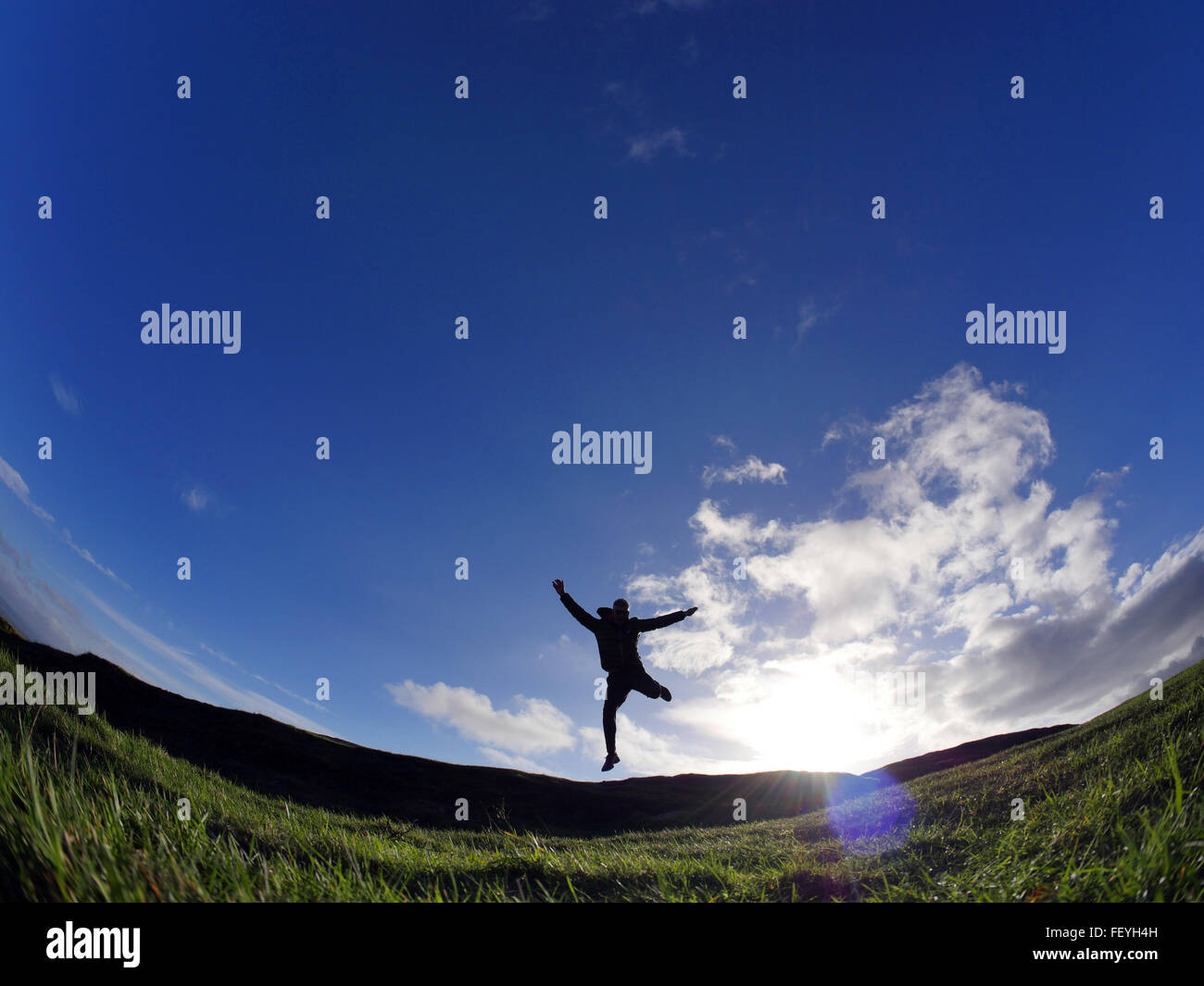 man leaping against blue sky Stock Photo - Alamy