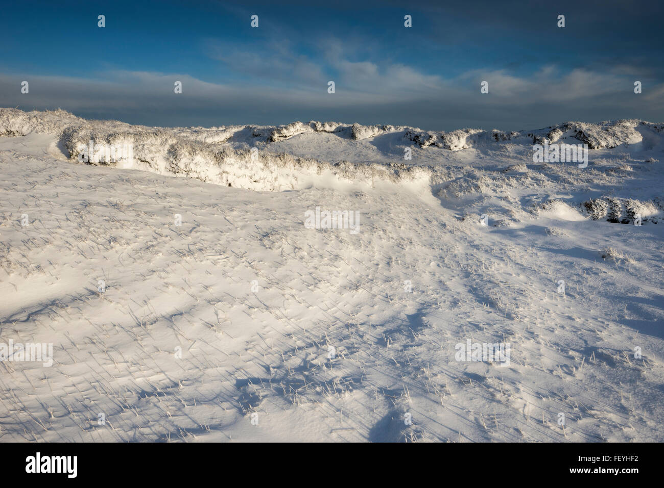 Wave like forms of peaty banks covered in snow on Bleaklow above ...