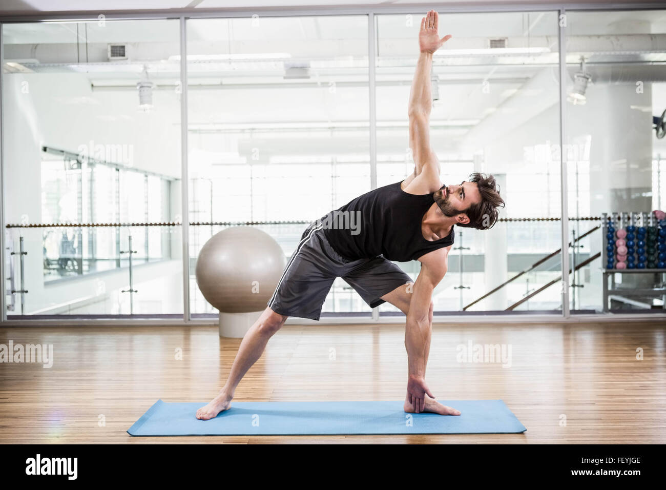 Handsome man doing yoga on mat Stock Photo - Alamy