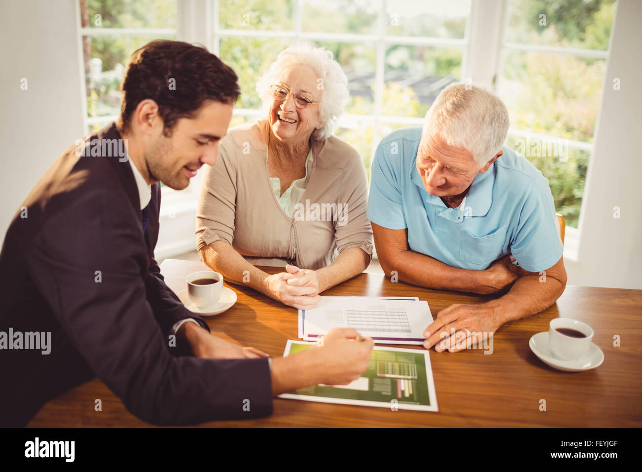 Businessman showing sheets to senior couple Stock Photo - Alamy