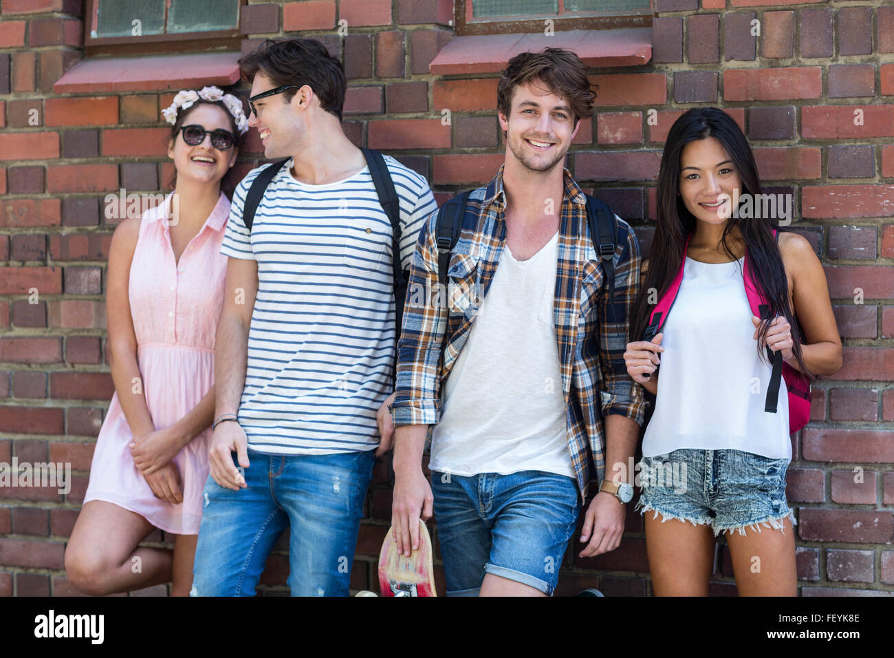 Hip friends leaning against wall Stock Photo - Alamy