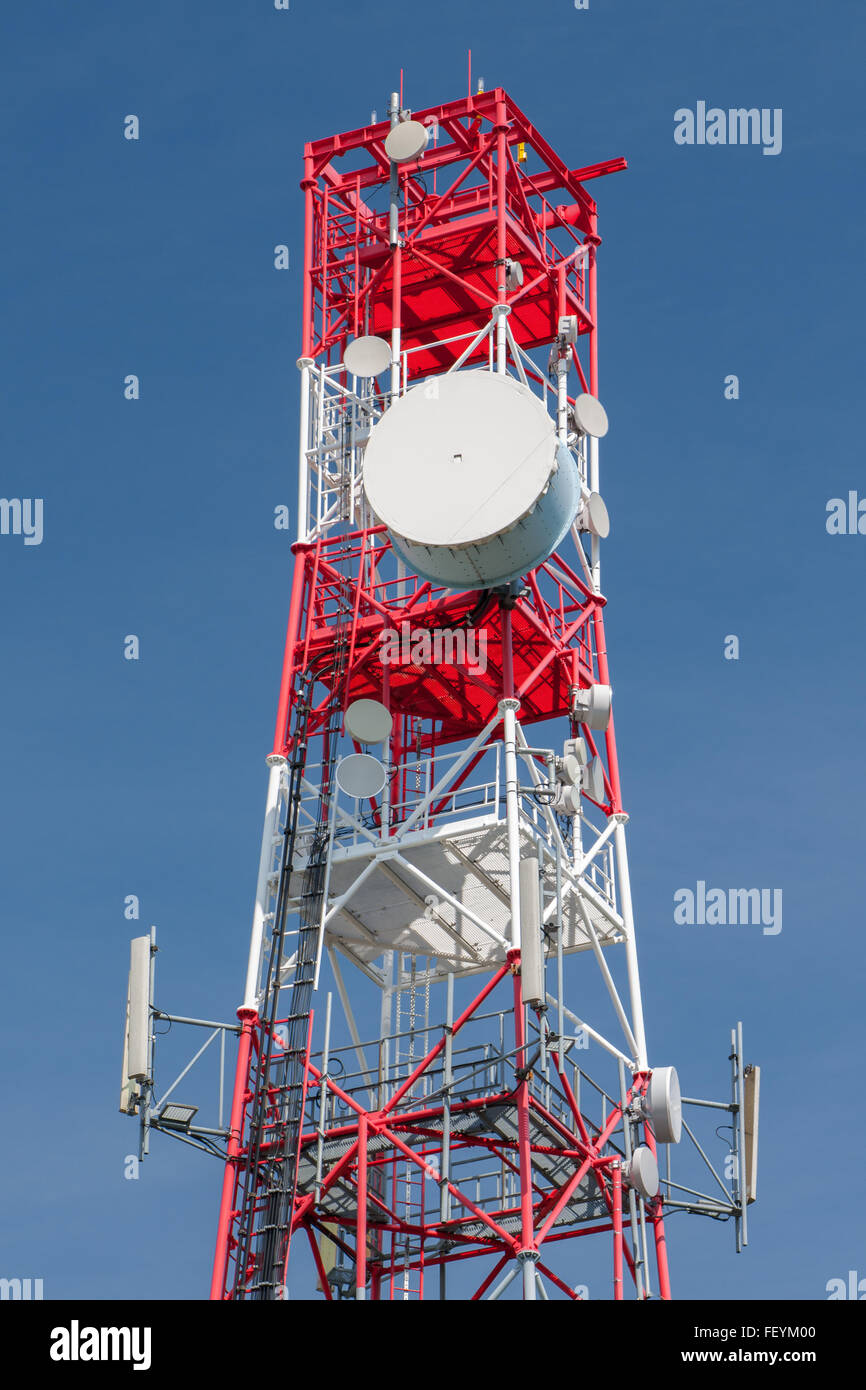 Multifunctional telecommunication tower - antennas on red and white ...