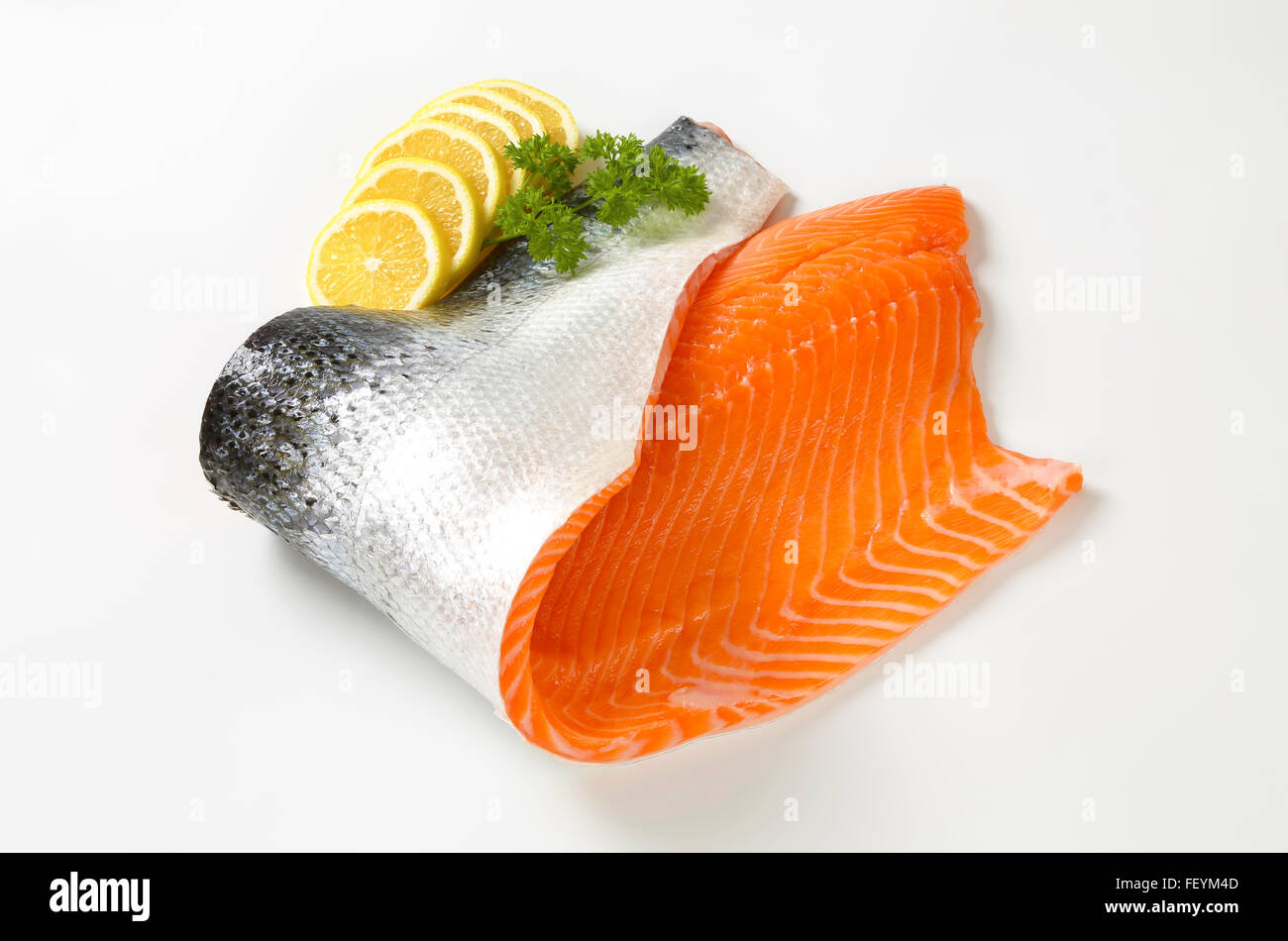 raw salmon fillet with silver skin and lemon slices on white background ...