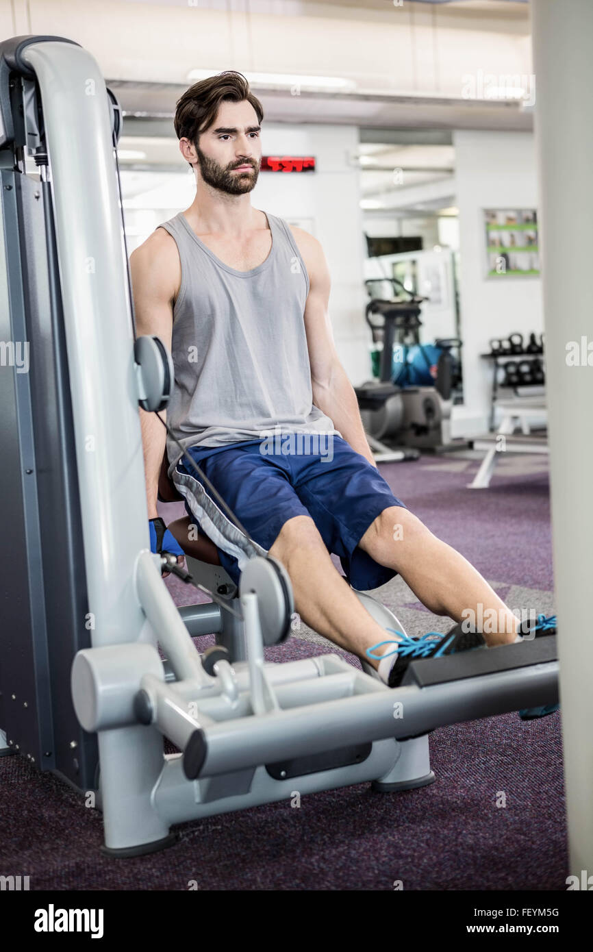 Focused man using weights machine for legs Stock Photo - Alamy