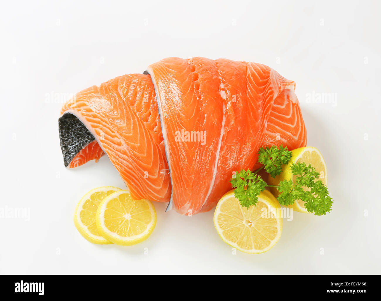 roll of raw salmon fillet and lemon on white background Stock Photo - Alamy