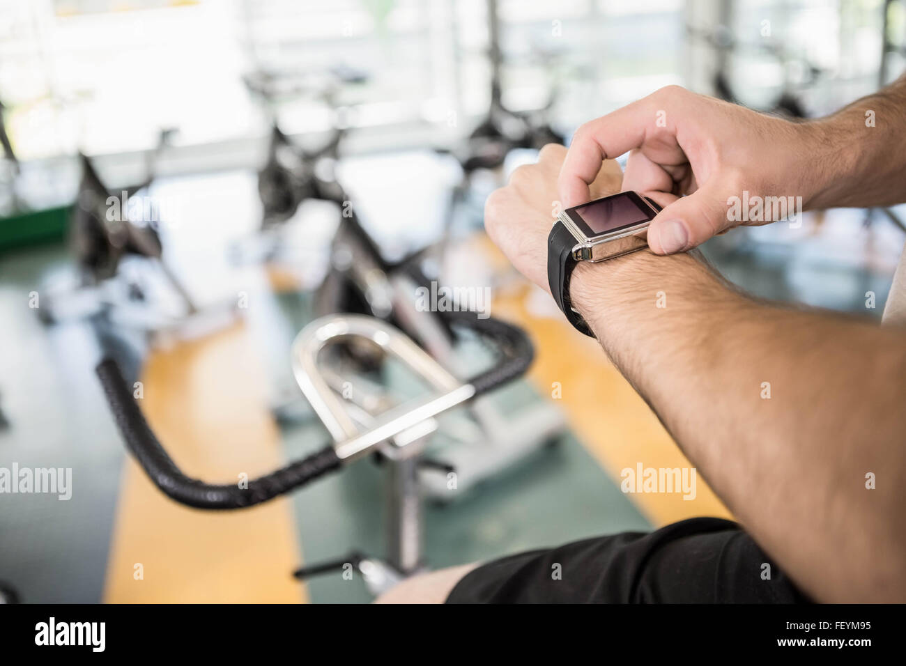 Close up of man using smartwatch on exercise bike Stock Photo - Alamy