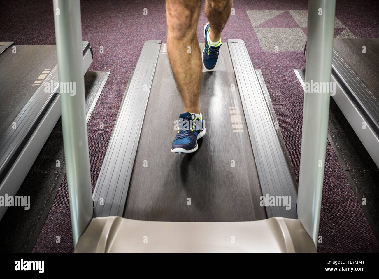 Lower section of man running on treadmill Stock Photo - Alamy