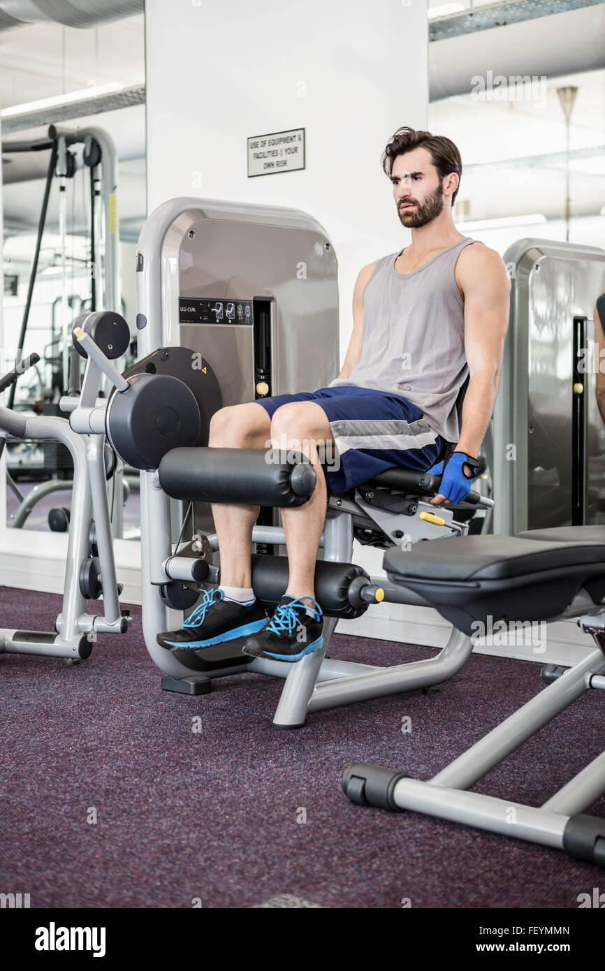 Focused man using weights machine for legs Stock Photo - Alamy