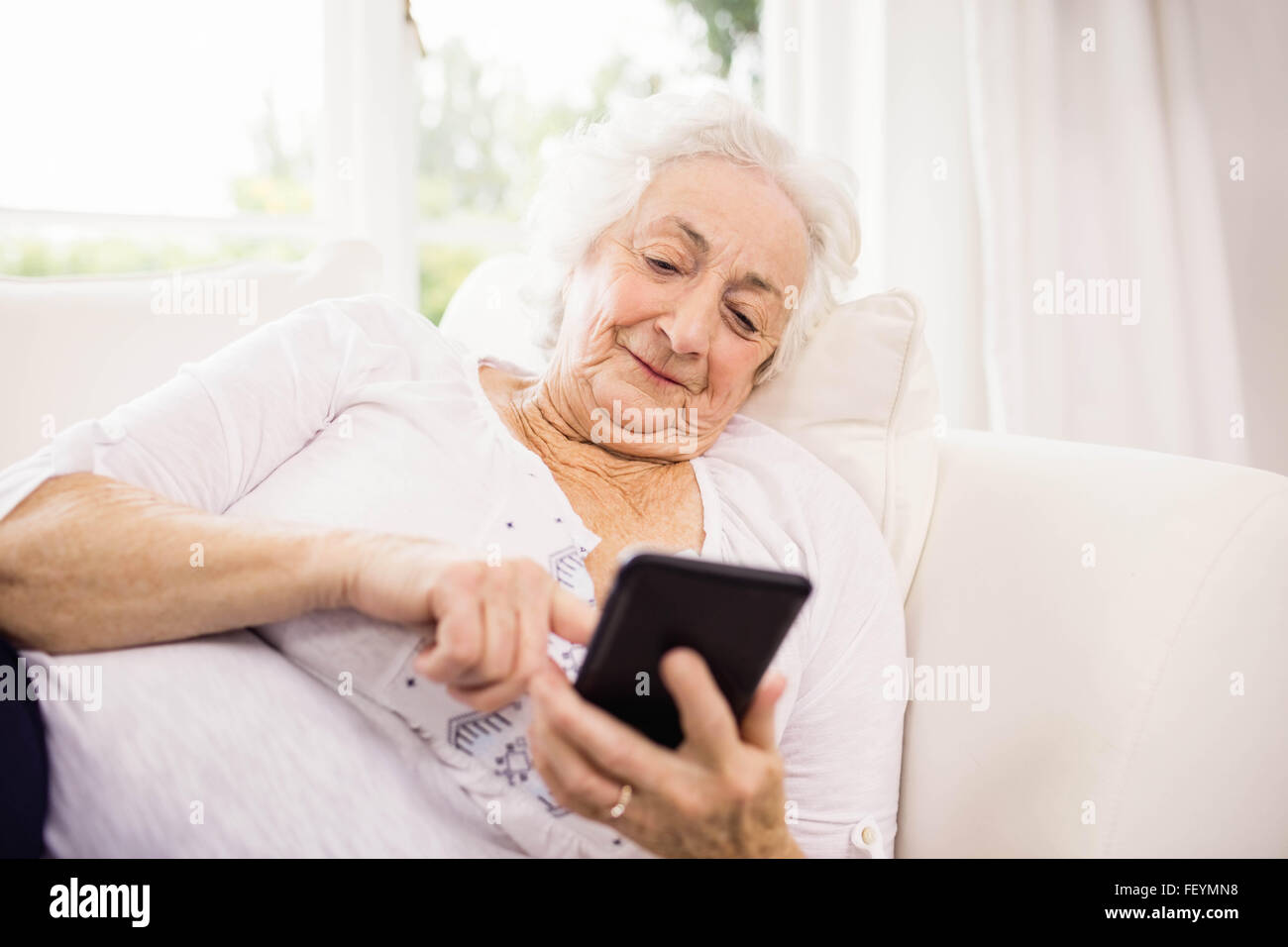 Elderly woman using her smartphone Stock Photo - Alamy