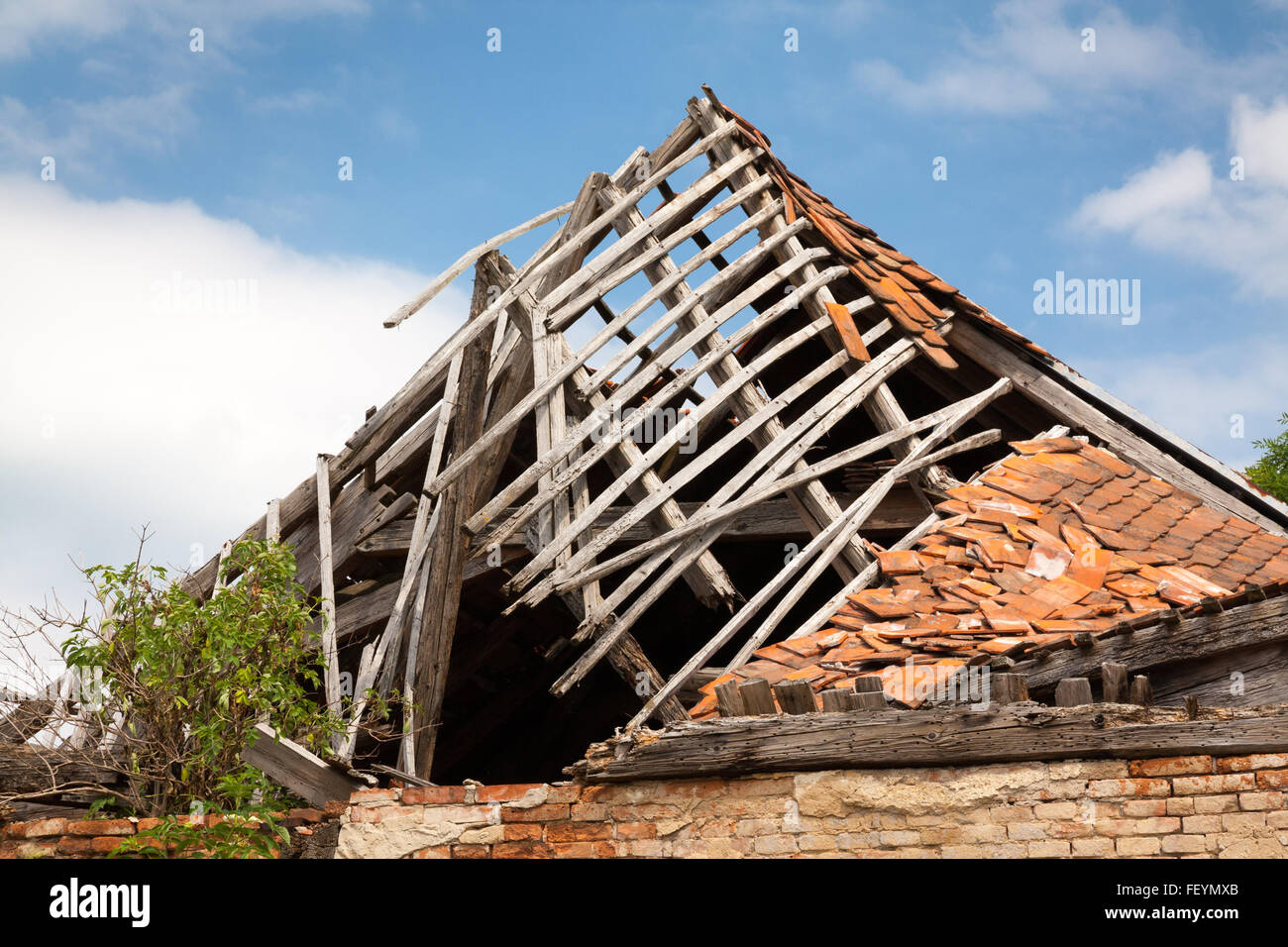 Ruined brick/wooden house - destroyed roof, vegetation Stock Photo - Alamy