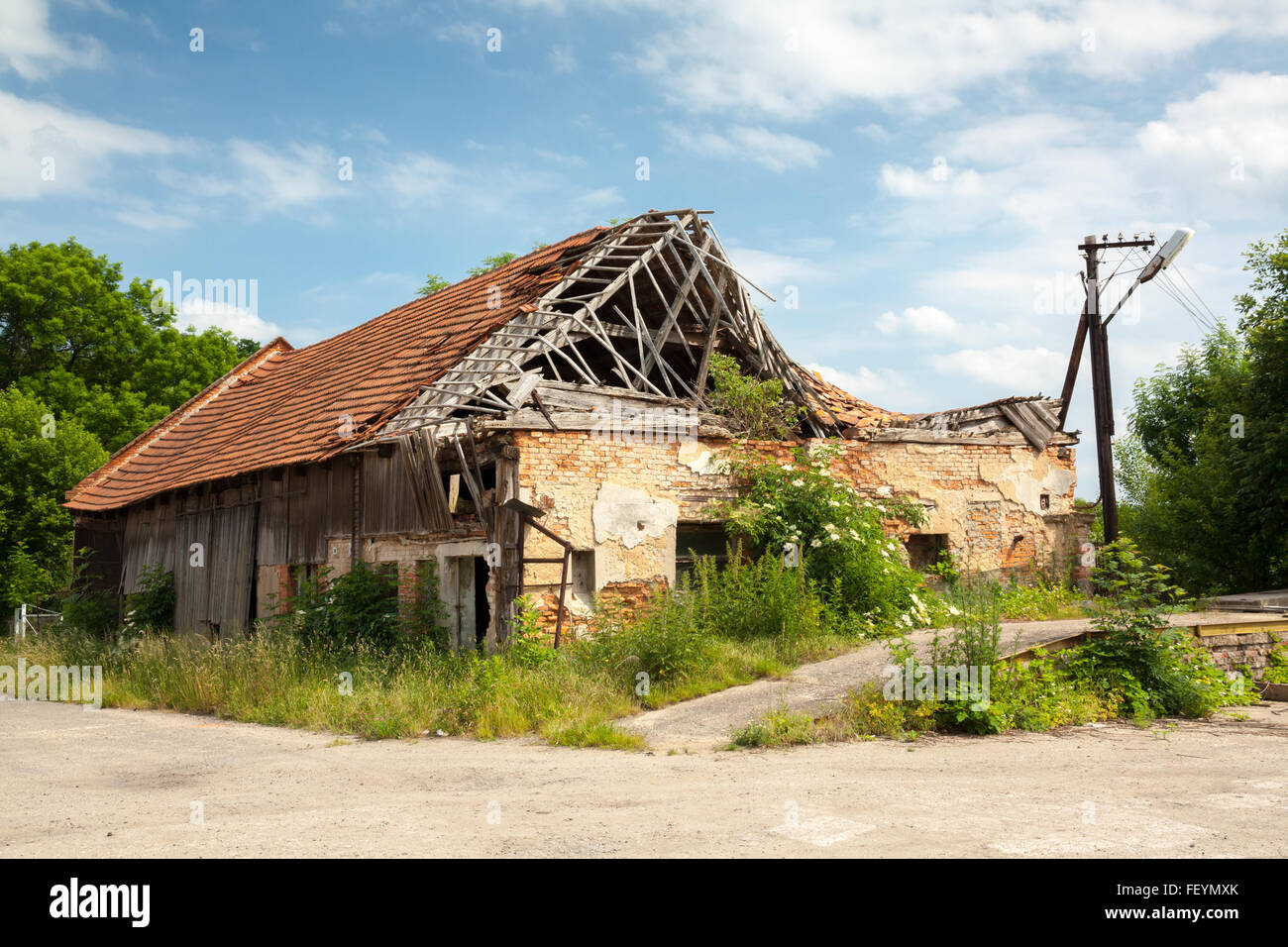 Ruined brick/wooden house - destroyed roof, vegetation Stock Photo - Alamy