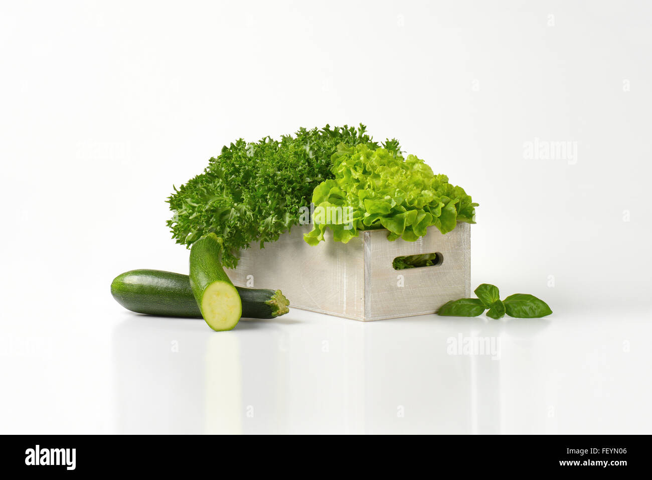 box of lettuce and courgette on white background Stock Photo - Alamy