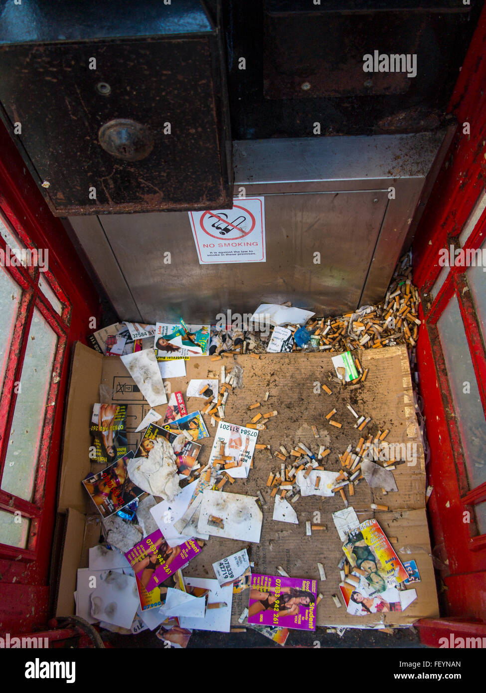 A filthy phone box with cigarette ends and prostitute cards Stock Photo ...