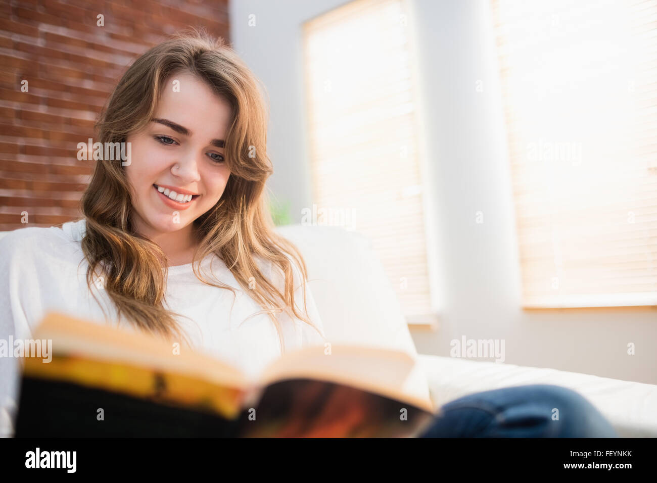 Smiling woman reading a book Stock Photo - Alamy