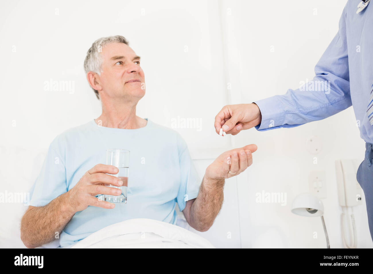 Male nurse giving pills to senior man Stock Photo - Alamy