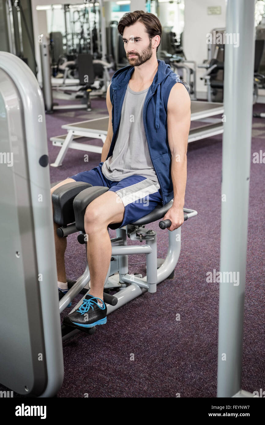 Focused man using weights machine for legs Stock Photo - Alamy