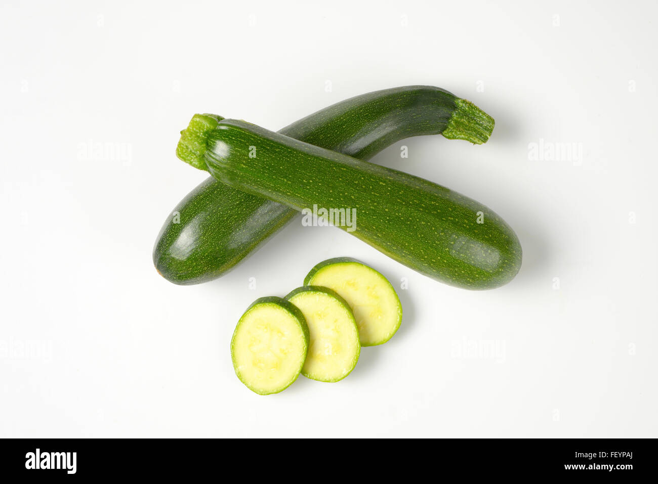 fresh courgettes and courgette slices on white background Stock Photo ...