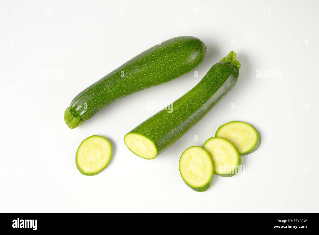 whole and sliced courgettes on white background Stock Photo - Alamy