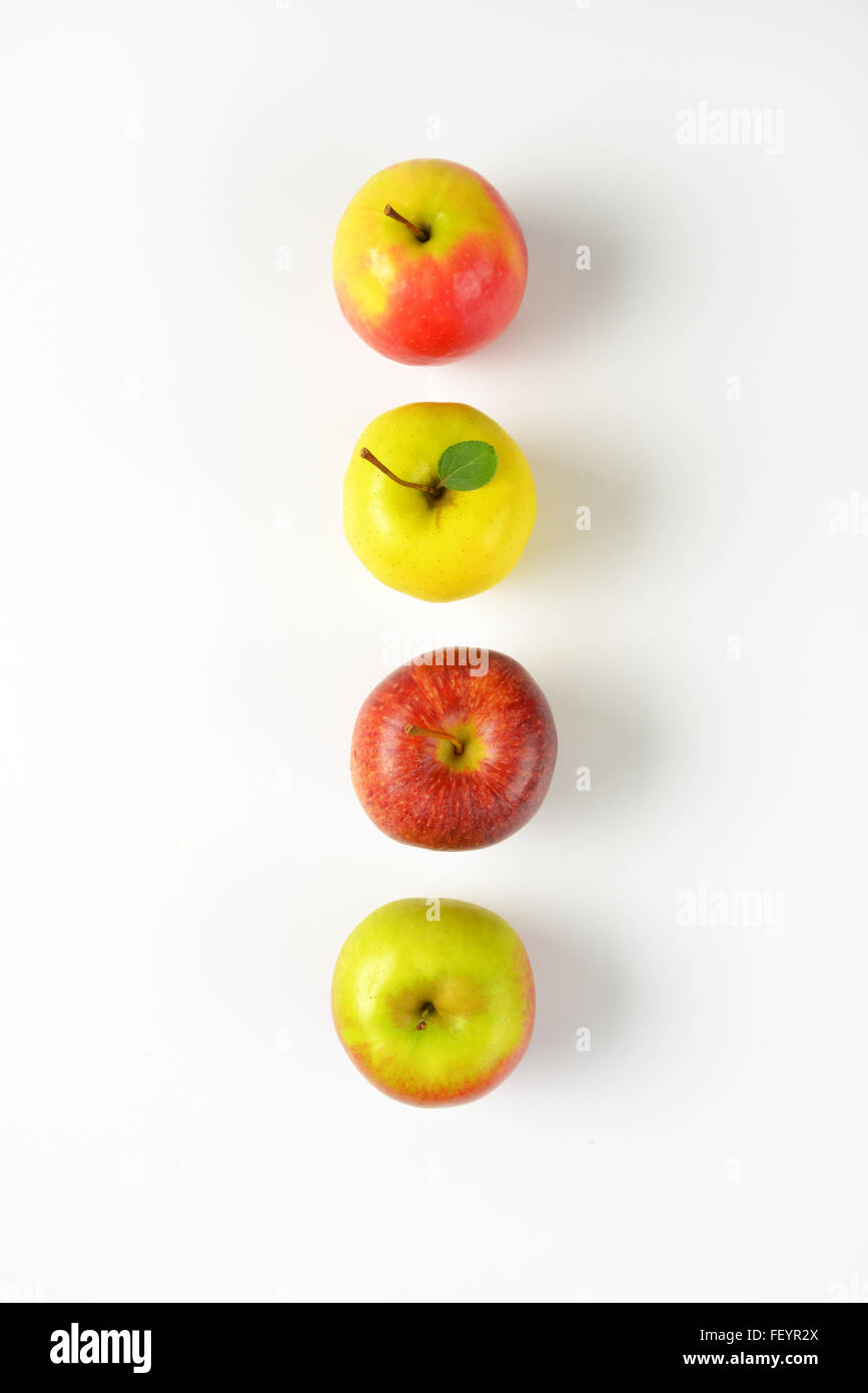 four ripe apples in a row on white background Stock Photo - Alamy