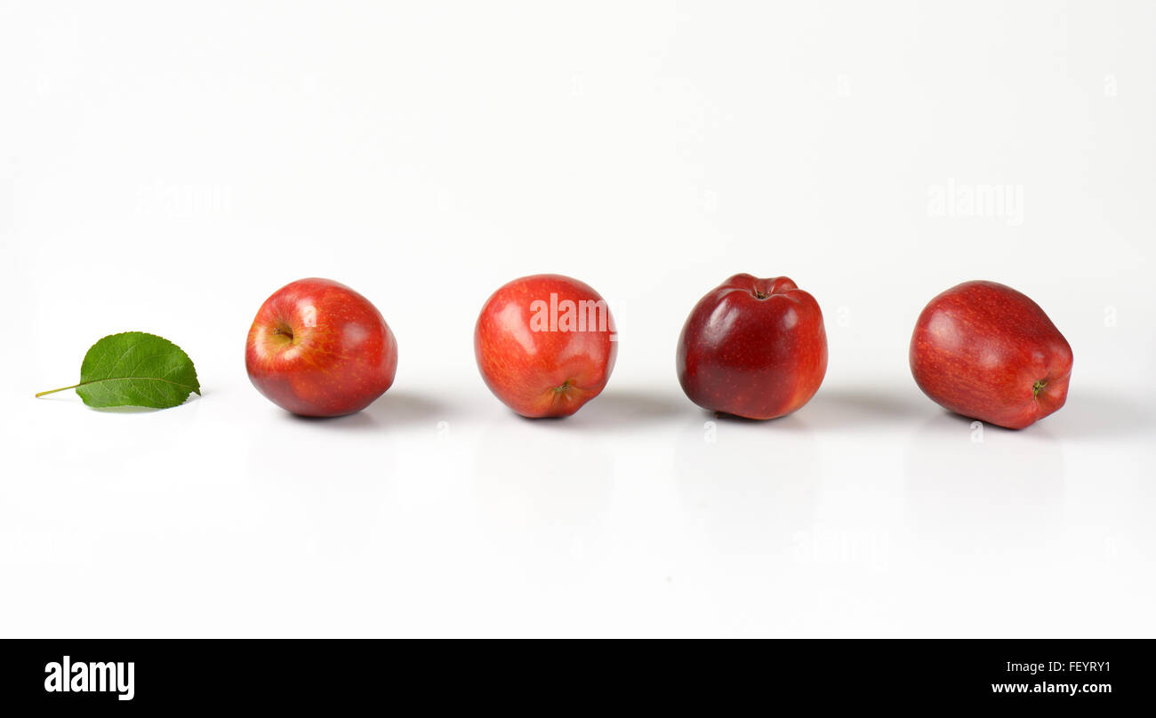 four ripe red apples in a row on white background Stock Photo - Alamy