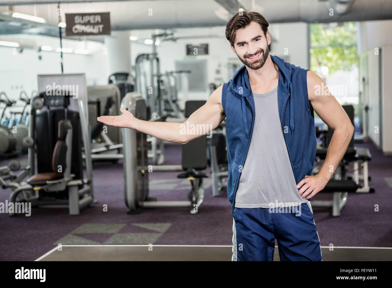 Smiling man showing the gym Stock Photo - Alamy