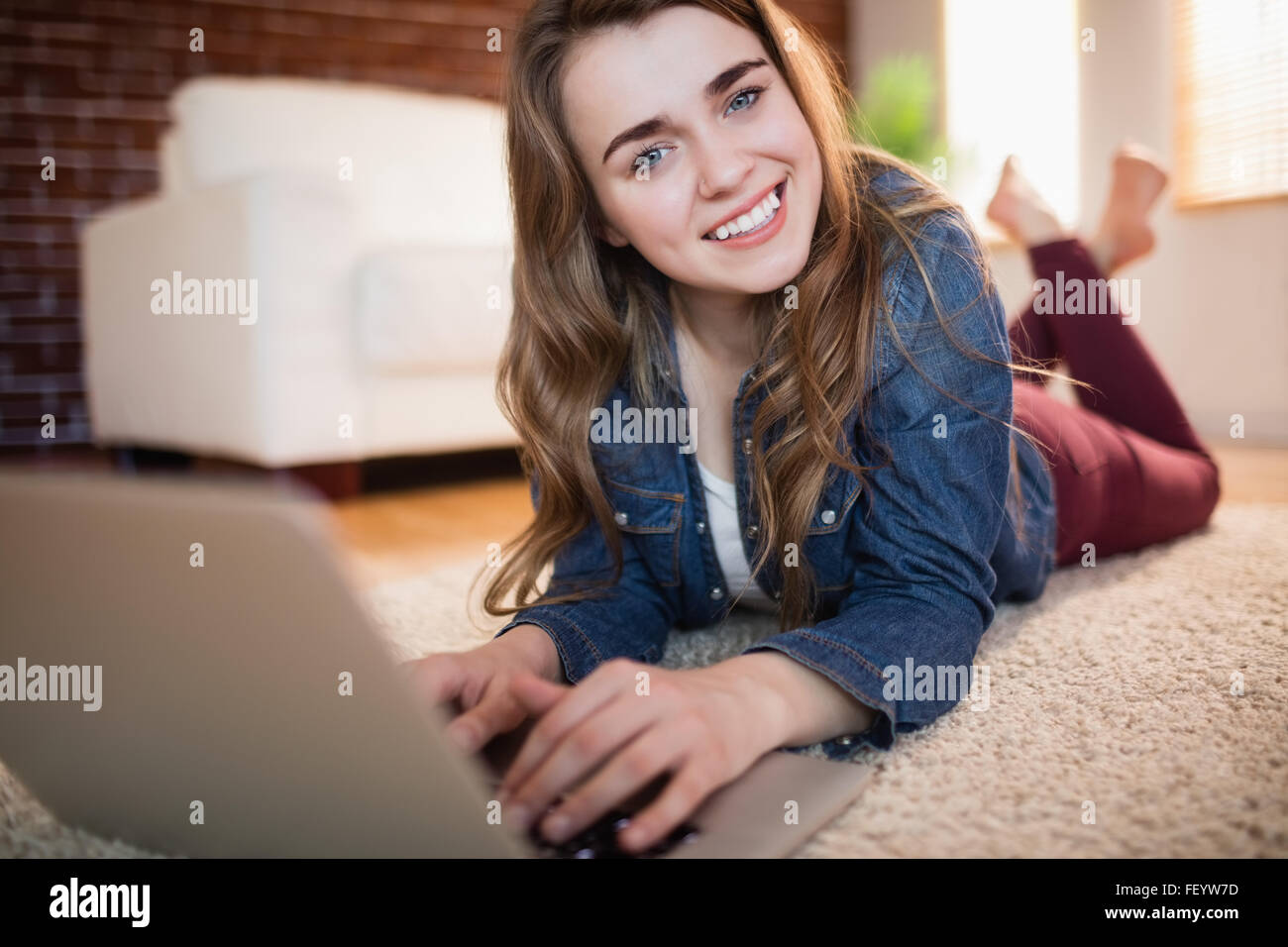 Pretty woman lying on the couch using laptop Stock Photo - Alamy