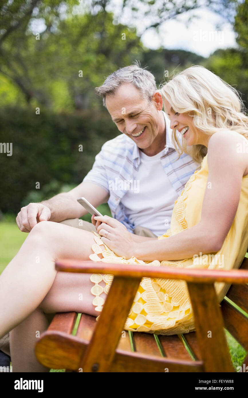 Happy couple sitting on a bench Stock Photo - Alamy