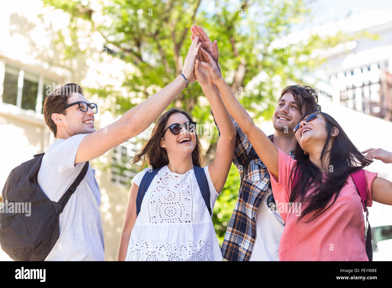 Hip friends doing high five Stock Photo - Alamy