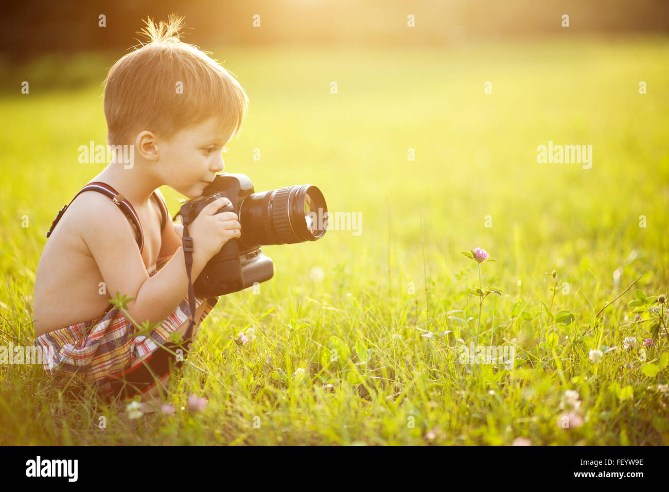 Sunny portrait of child with camera Stock Photo - Alamy