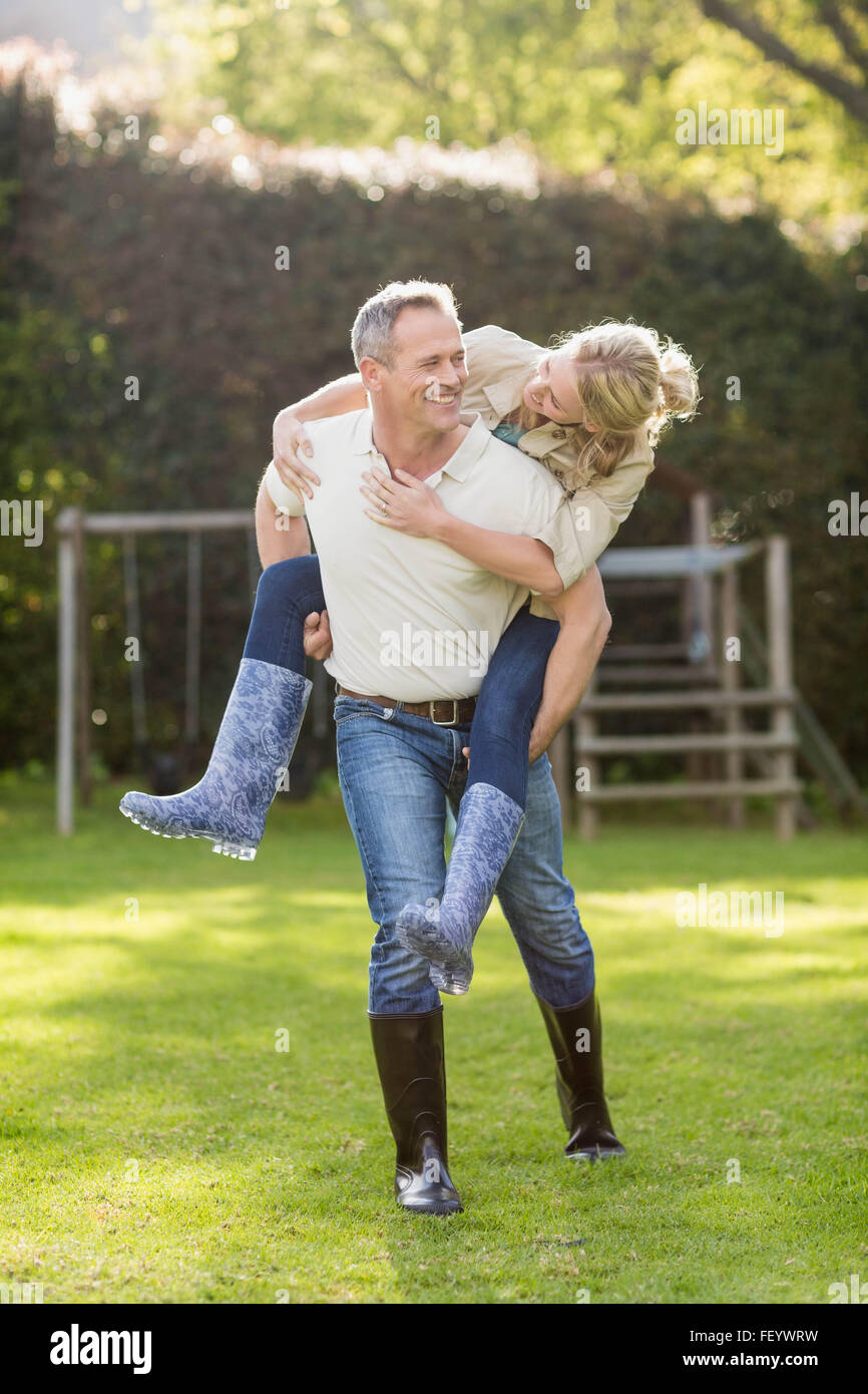 Husband giving piggy back to wife Stock Photo - Alamy