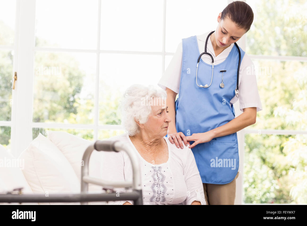 Nurse taking care of sick elderly woman Stock Photo - Alamy