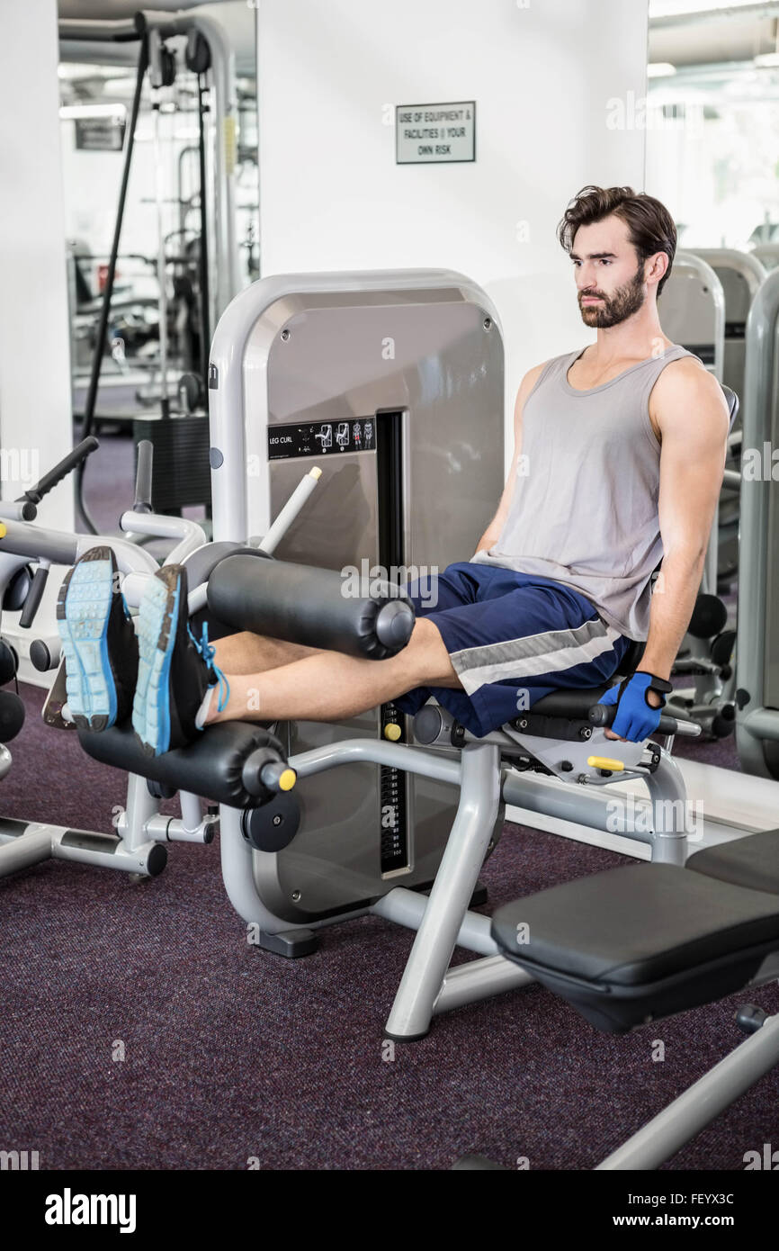 Focused man using weights machine for legs Stock Photo - Alamy