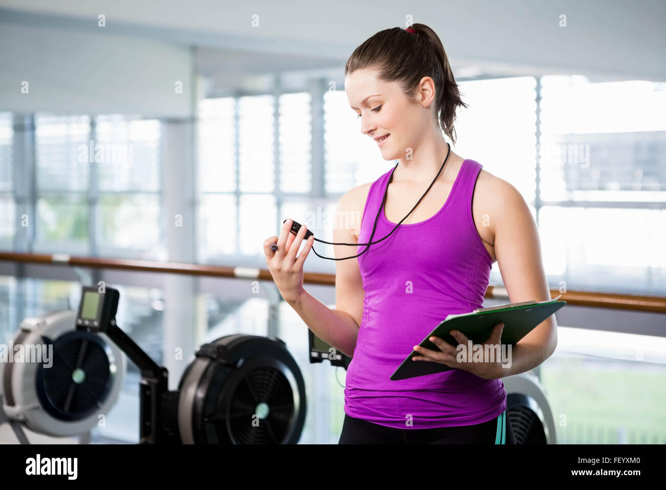 Smiling trainer looking at stopwatch Stock Photo - Alamy