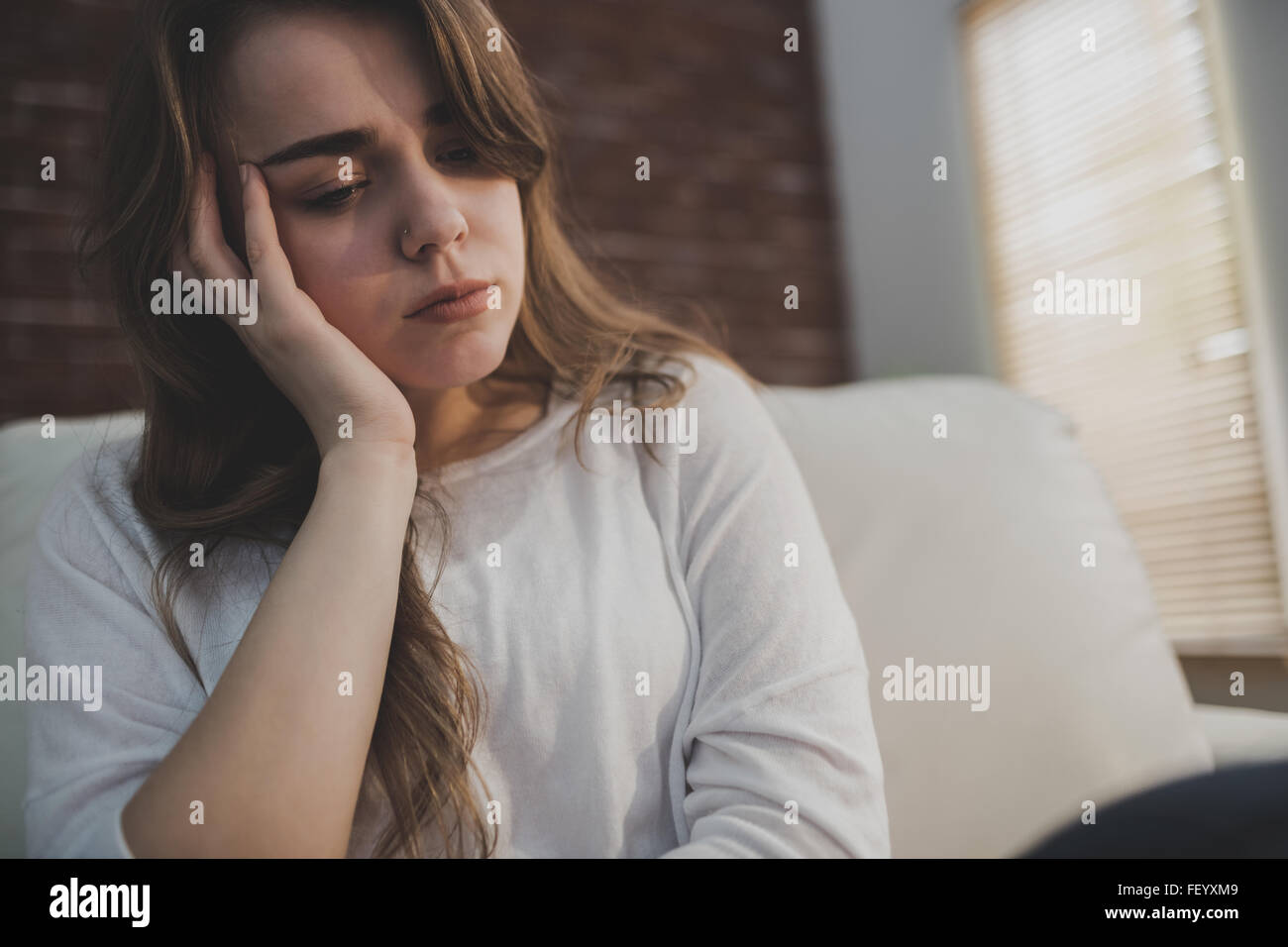 Upset woman sitting on the couch Stock Photo - Alamy