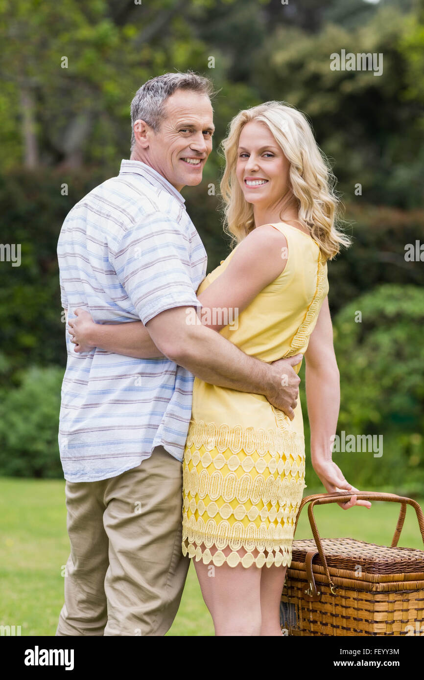 Happy couple holding picnic basket Stock Photo - Alamy