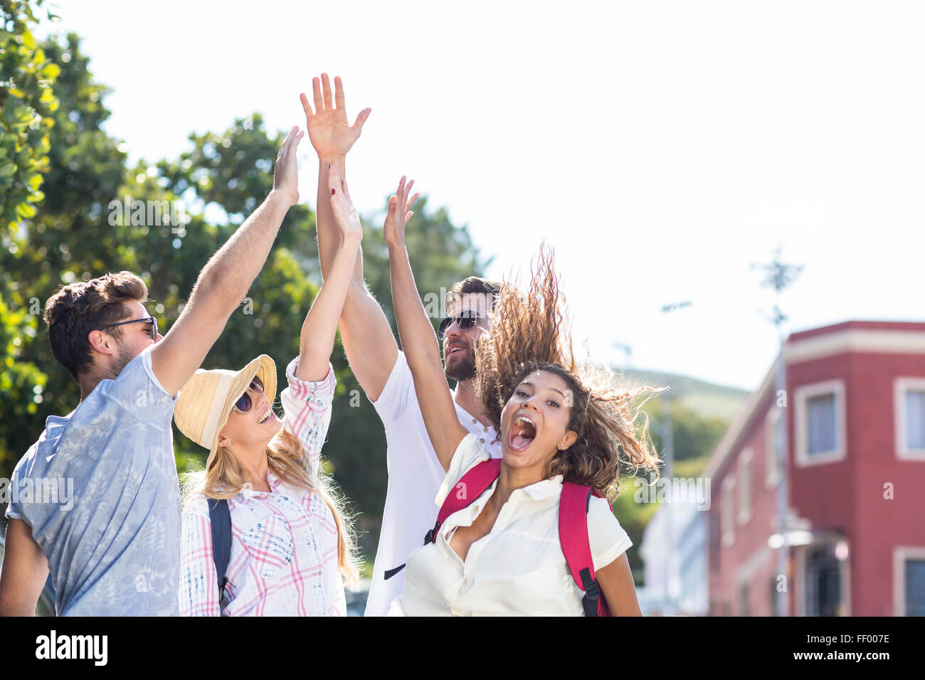 Hip friends doing high-five Stock Photo - Alamy