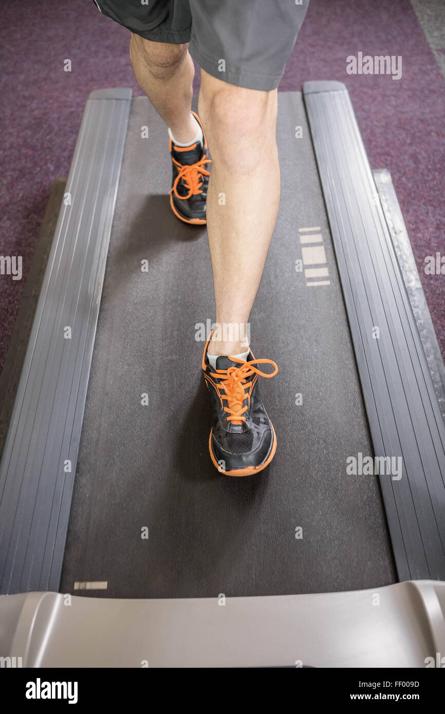 Lower section of man running on treadmill Stock Photo - Alamy