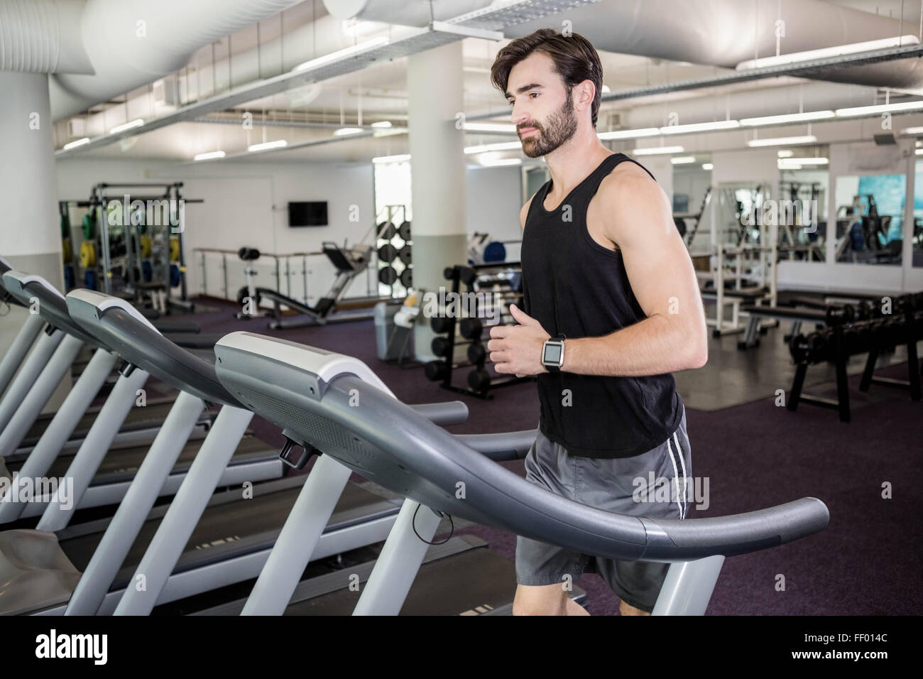 Serious man running on treadmill Stock Photo - Alamy