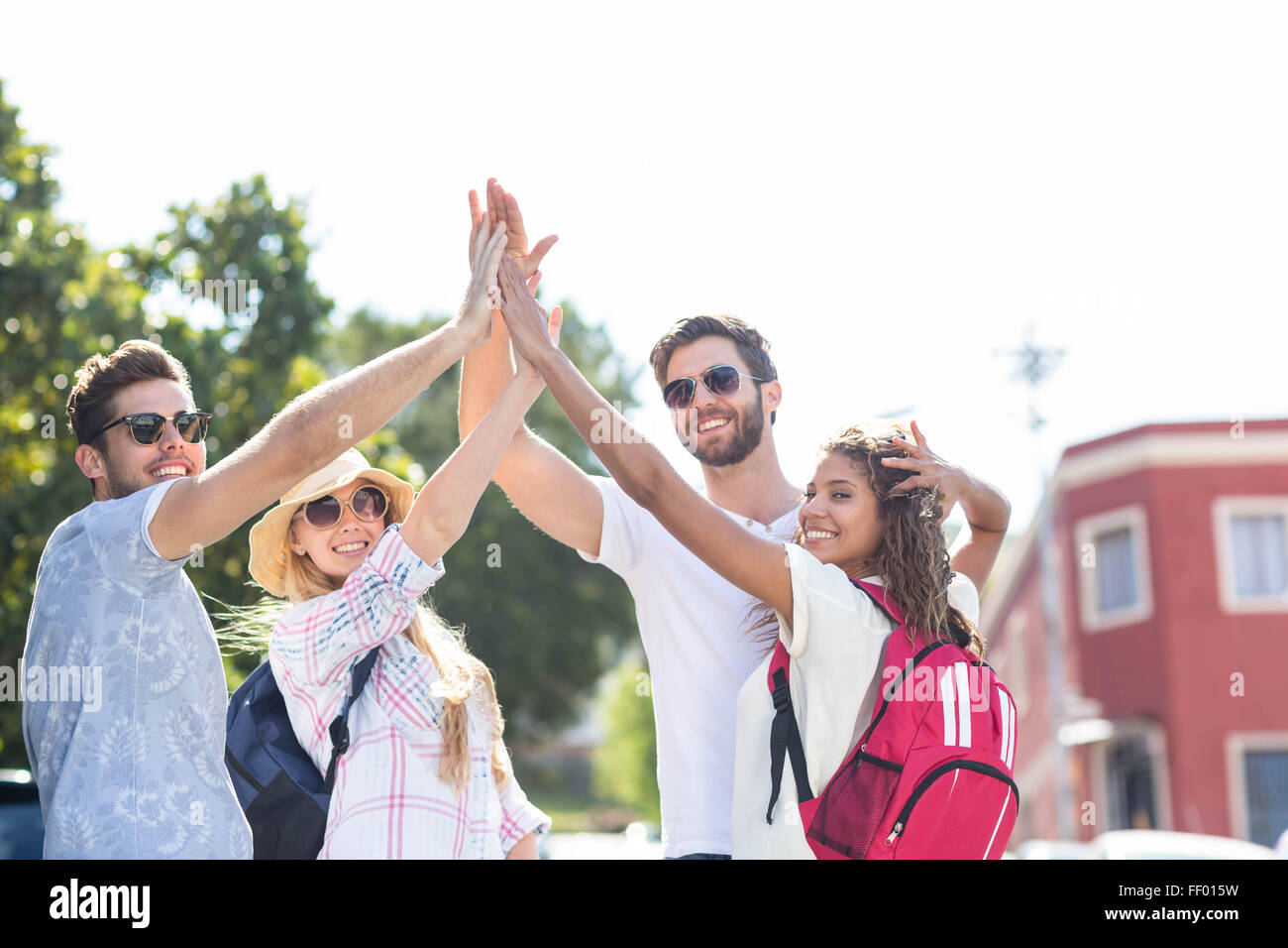 Hip friends doing high-five Stock Photo - Alamy