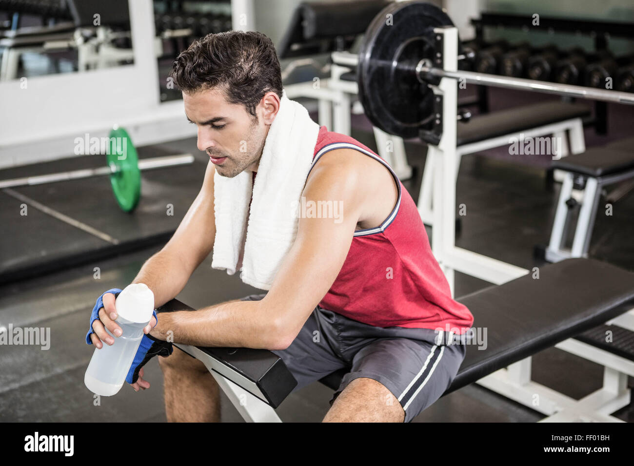 Tired man sitting on bench holding bottle of water Stock Photo - Alamy
