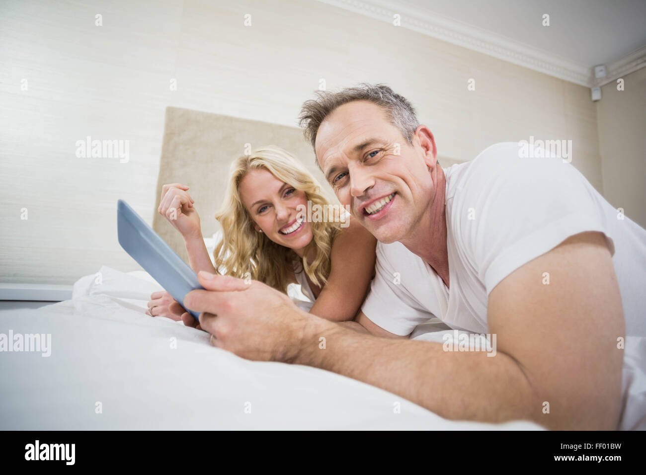 Cute couple using tablet Stock Photo - Alamy