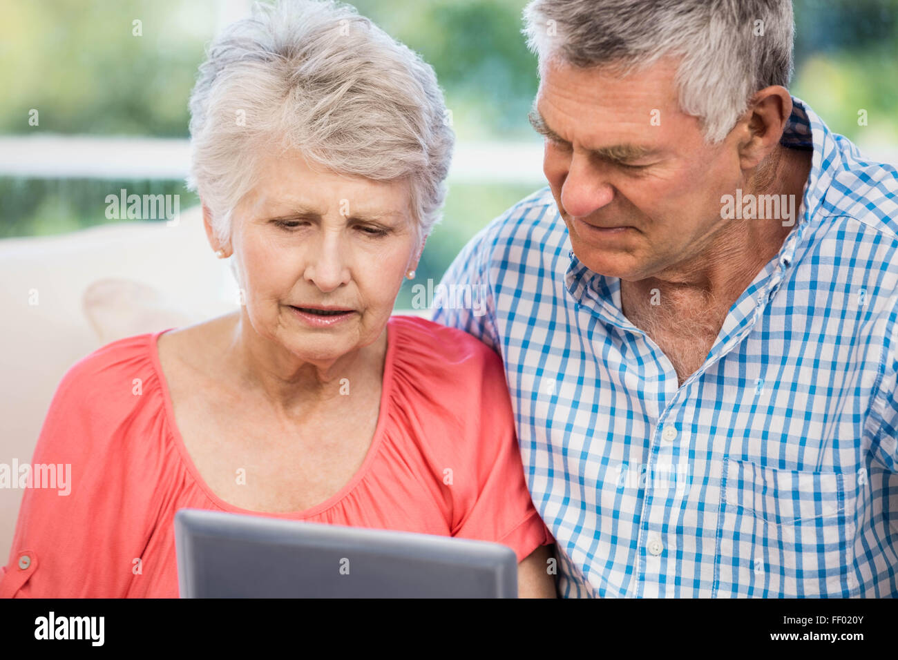 Doubtful senior couple using tablet Stock Photo - Alamy