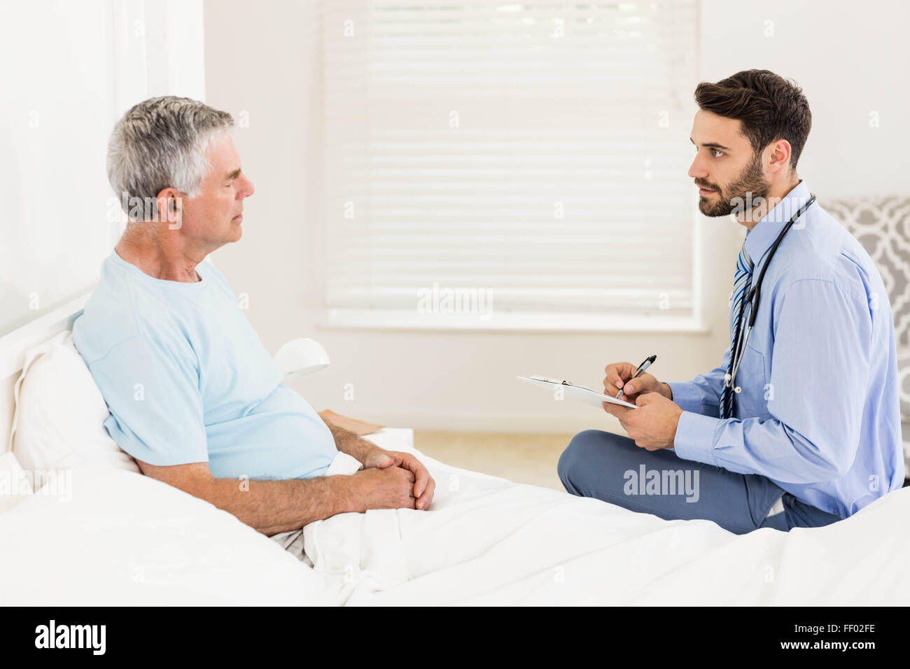 Handsome nurse visiting a mature man Stock Photo - Alamy