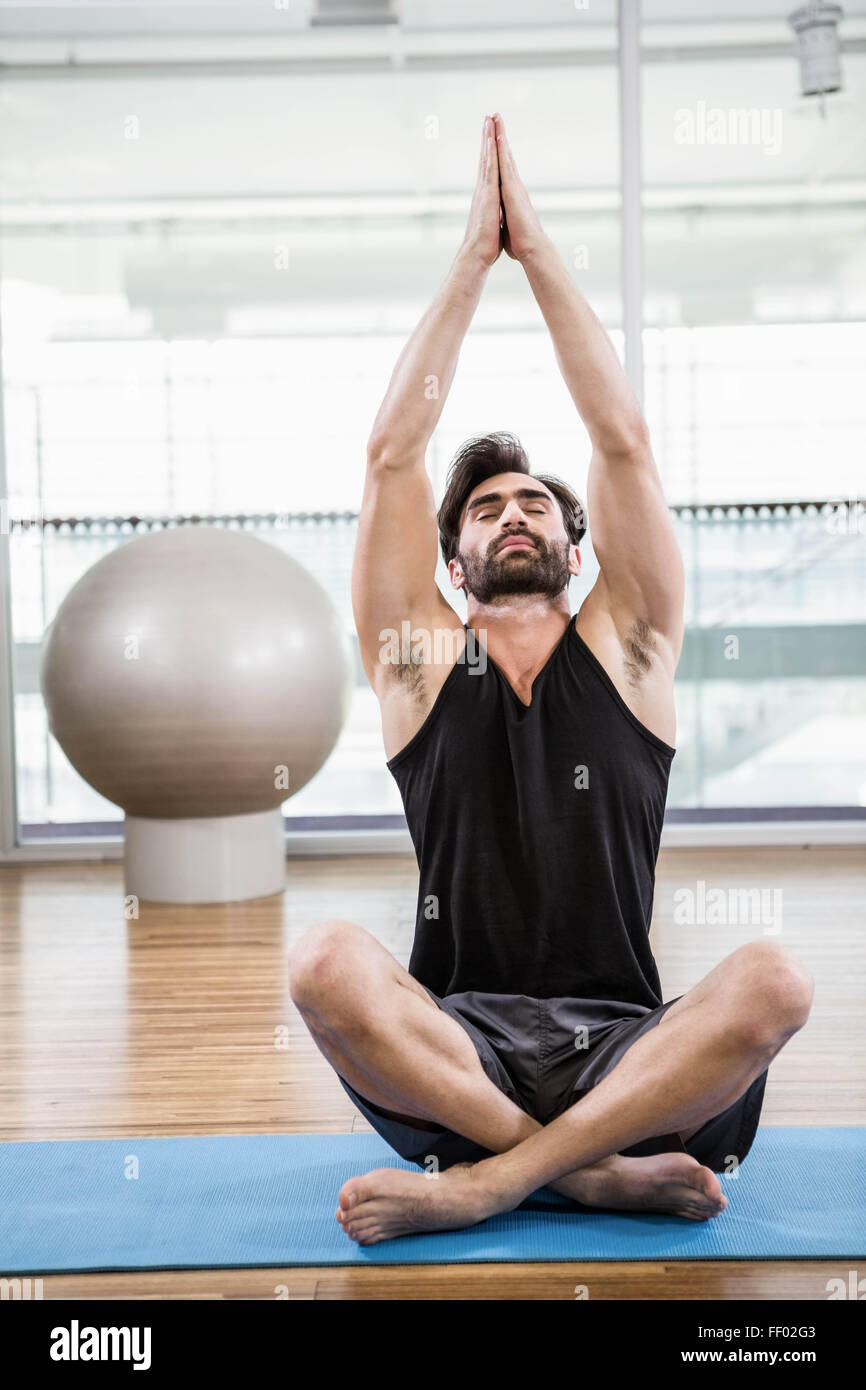 Handsome man doing yoga on mat Stock Photo - Alamy