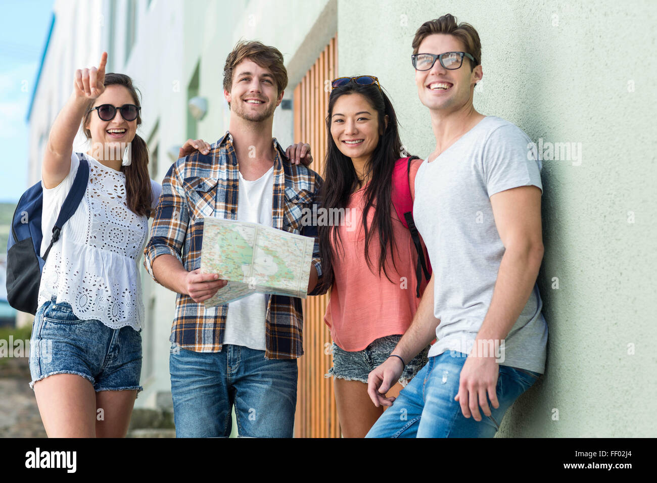 Hip friends checking map Stock Photo - Alamy
