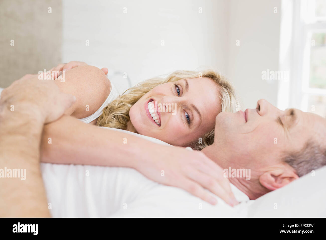 Cute couple cuddling in bed Stock Photo - Alamy